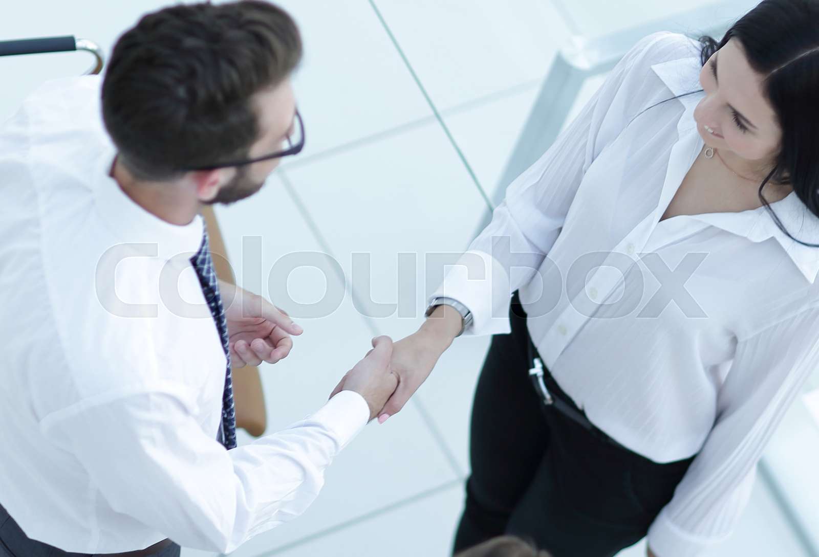 handshake manager and employee near the workplace | Stock image | Colourbox