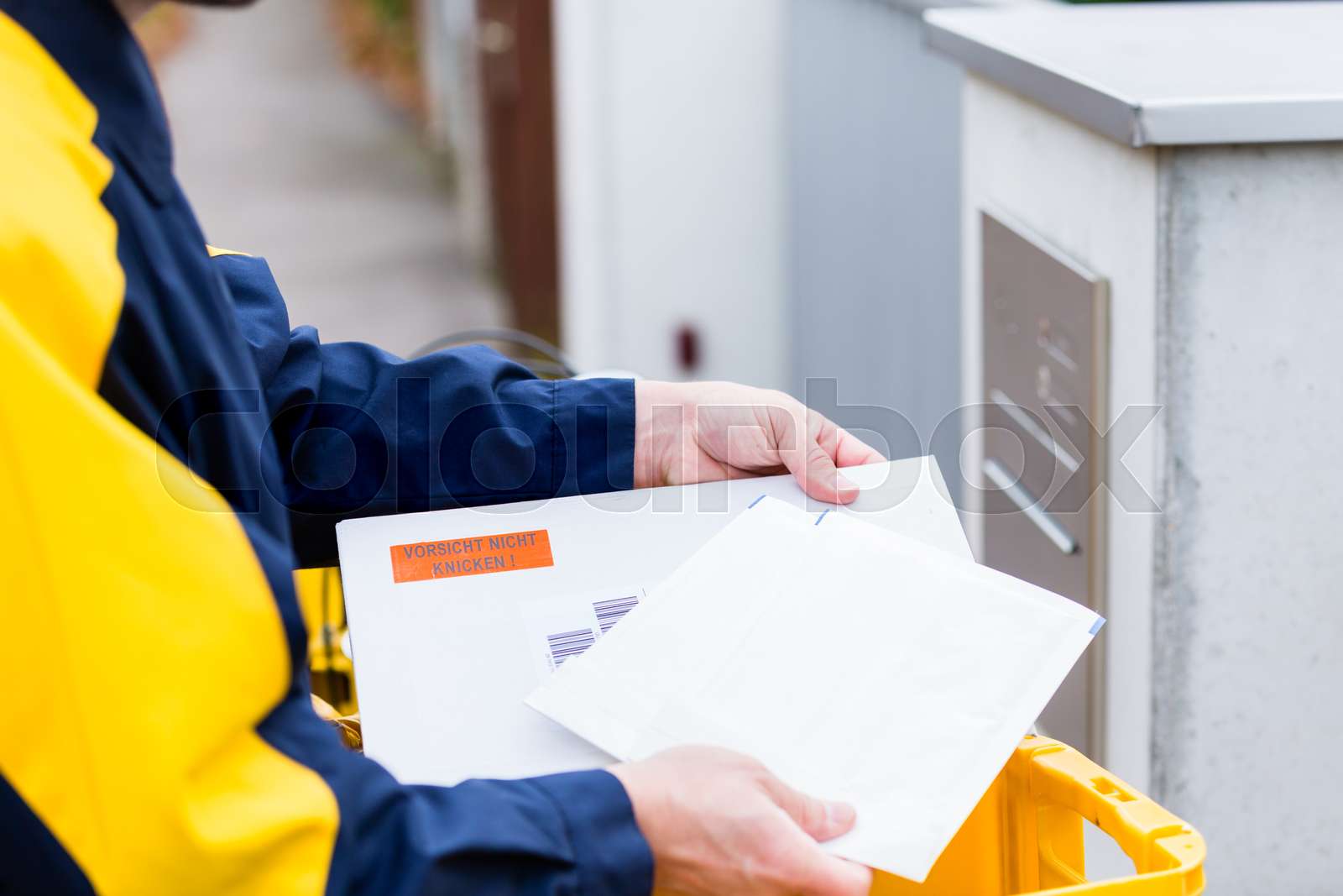 Postman delivering letters to mailbox of recipient | Stock image ...