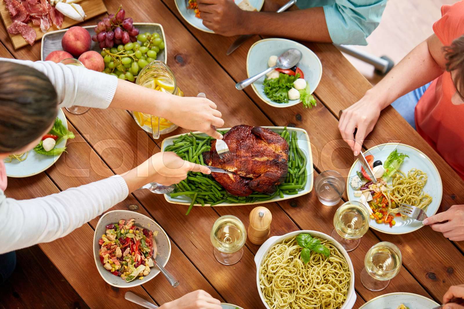 group of people eating chicken for dinner | Stock image | Colourbox