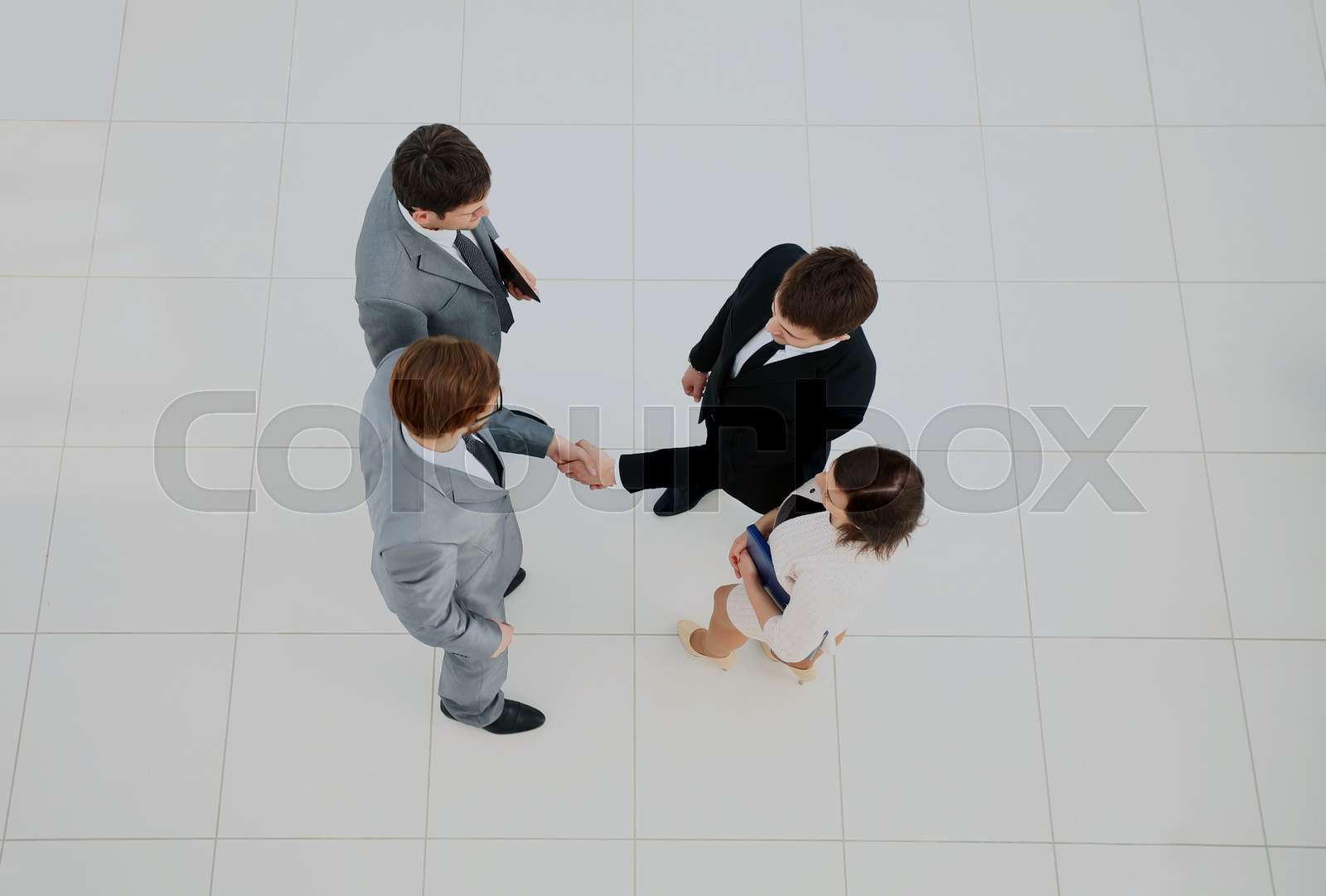 Business meeting. Top view of four people in formalwear standing close ...