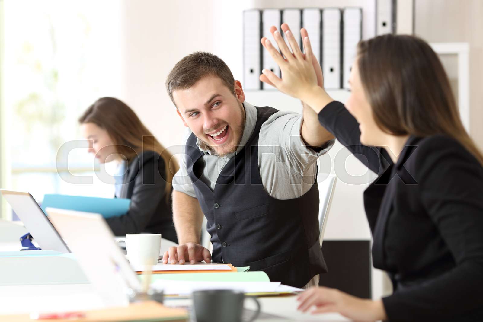 Coworkers celebrating achievement at office | Stock image | Colourbox
