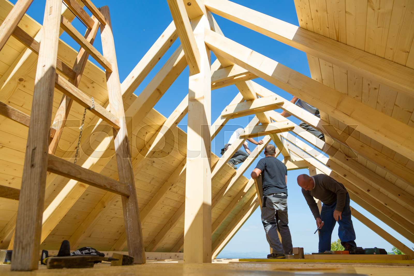 Builders at work with wooden roof construction. | Stock image | Colourbox