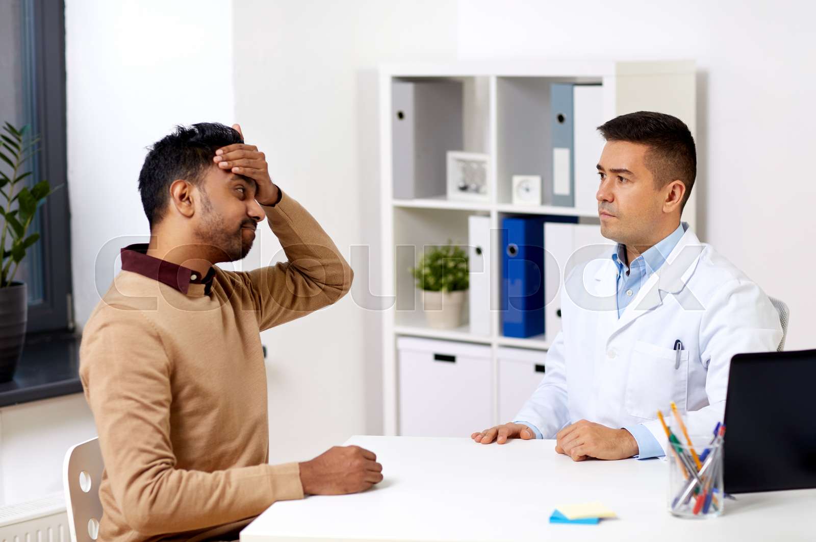 doctor and patient with headache at hospital | Stock image | Colourbox