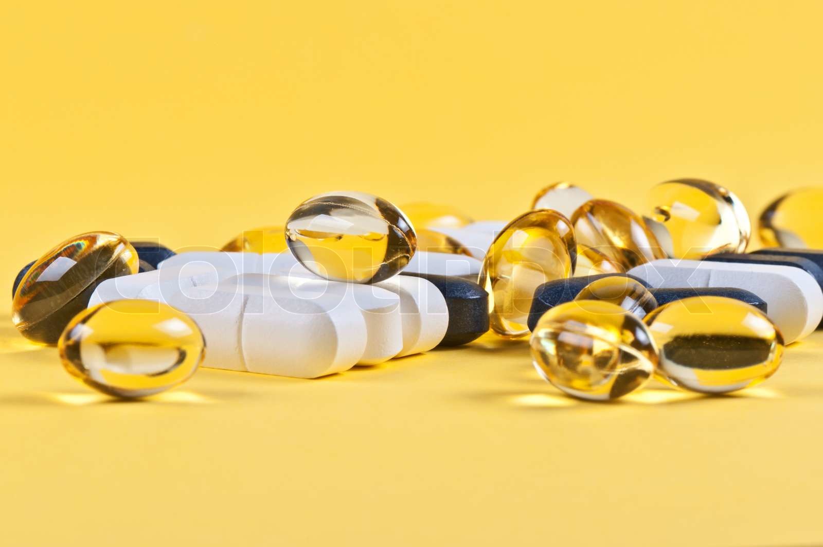 Hvide og sorte piller på gul baggrund | Stock foto | Colourbox