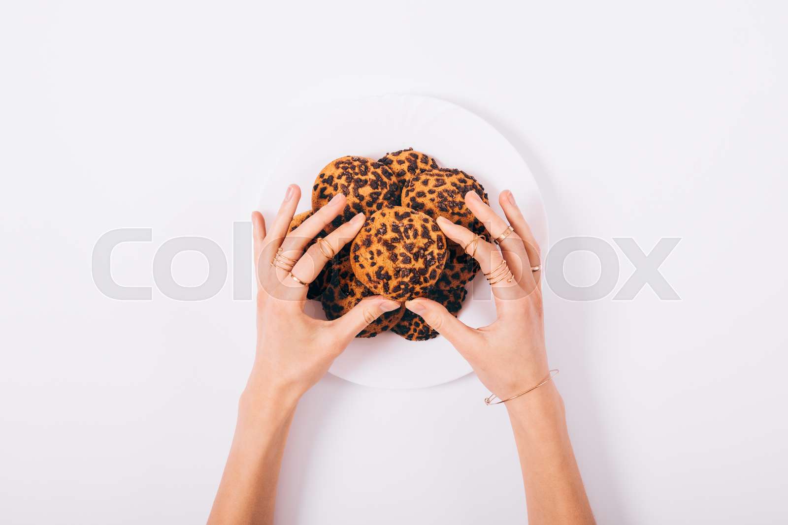 Female hands take a cookie from a plate | Stock image | Colourbox