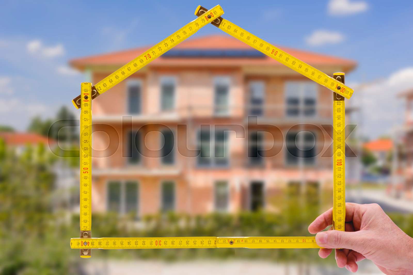 Gefalteter Meterstab in Hand eines Maklers als Angebot fürs neue ...