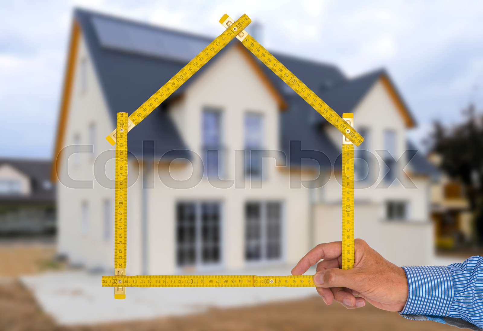 Gefalteter Meterstab in Hand eines Maklers als Angebot fürs neue ...