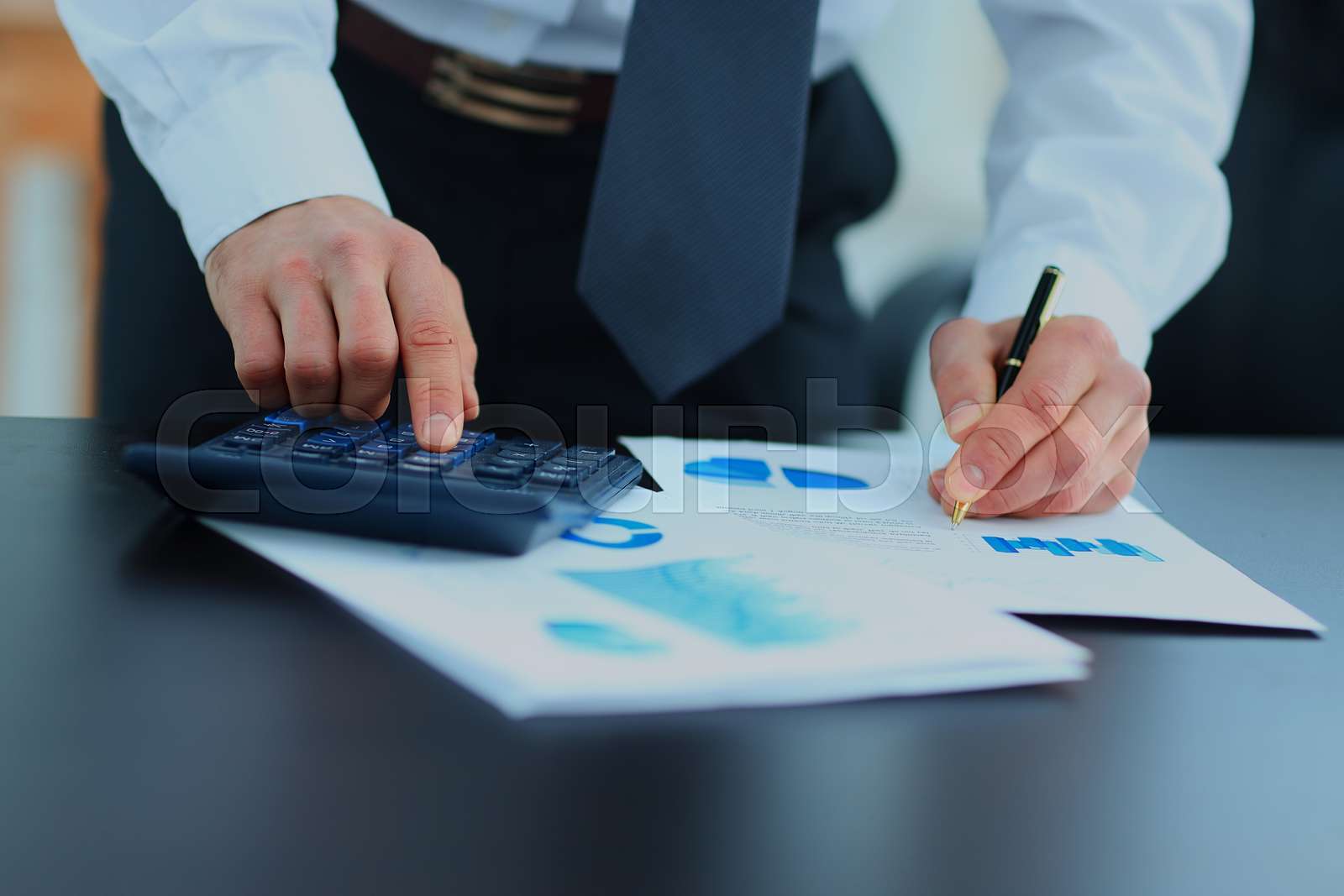 Businessman Using Calculator In Office. | Stock image | Colourbox