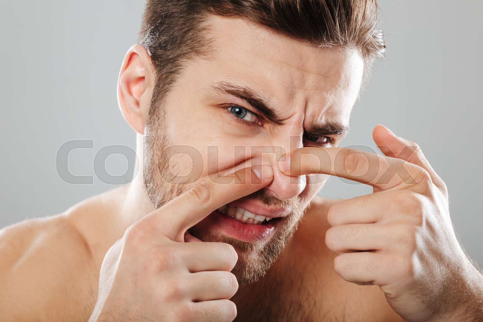 Close up portrait of a man squeezing pimple on his face | Stock image ...