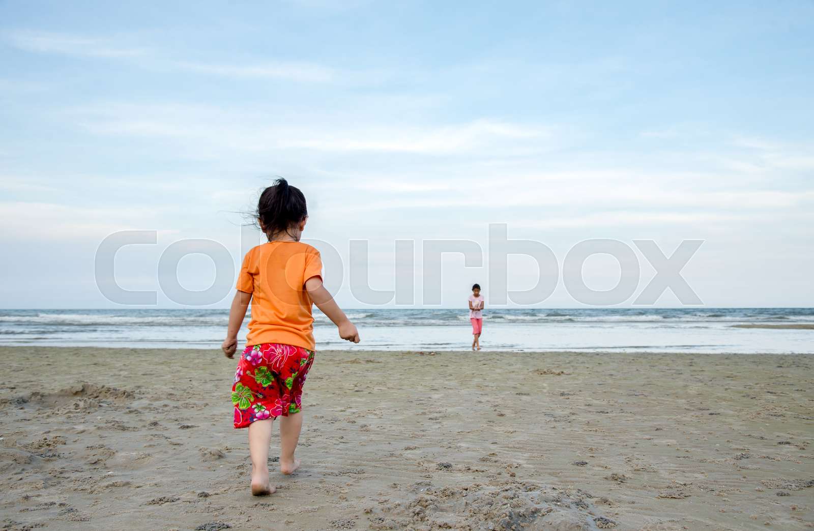 Back of child playing sand at the beach. | Stock image | Colourbox