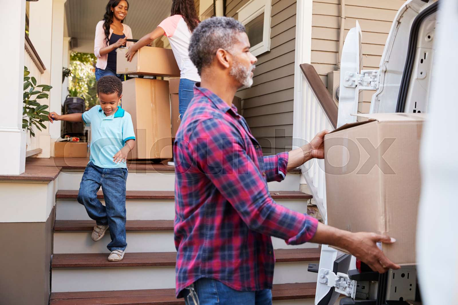 Children Helping Children With Boxes On Moving In Day | Stock image ...