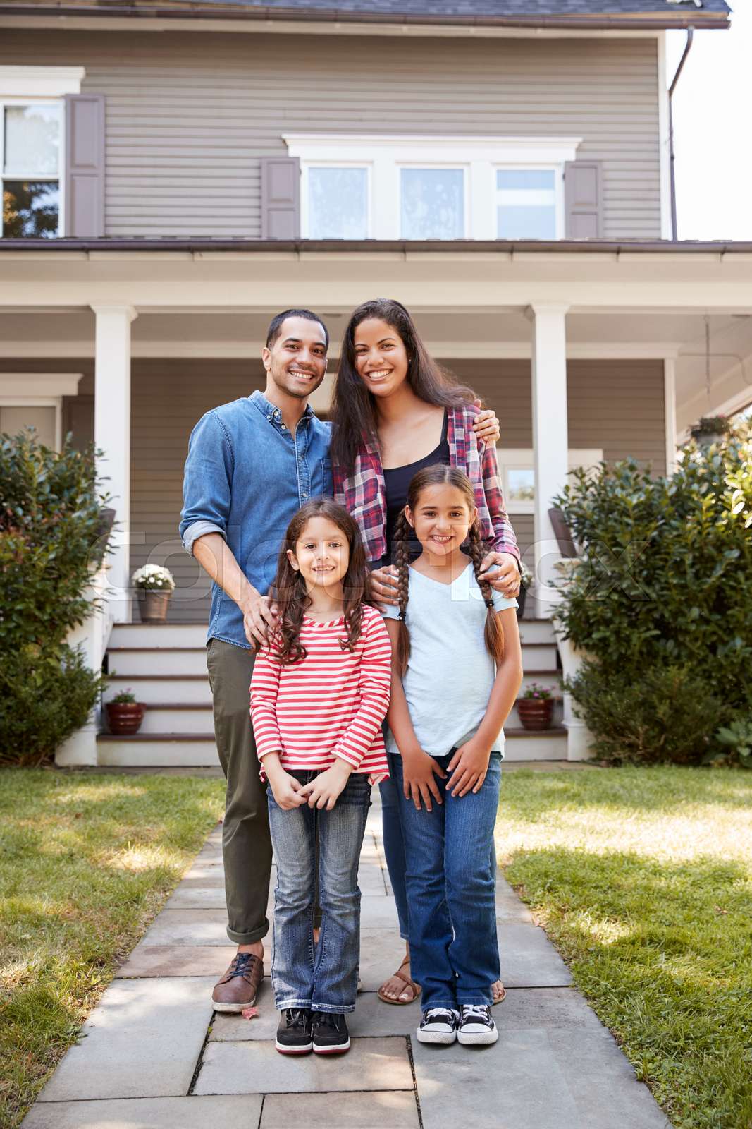 Portrait Of Smiling Family Standing In Front Of Their Home | Stock ...