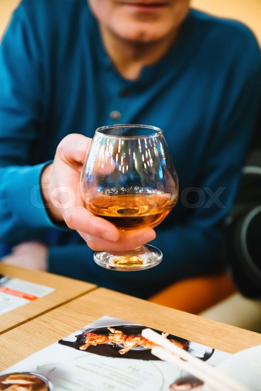 Man holding a glass of alcohol drink whiskey | Stock image | Colourbox