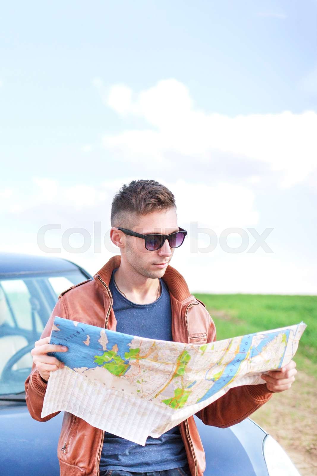 Young man reading road map | Stock image | Colourbox