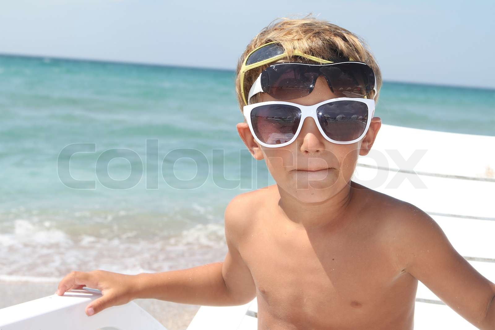 ung dreng slapper af på stranden | Stock foto | Colourbox