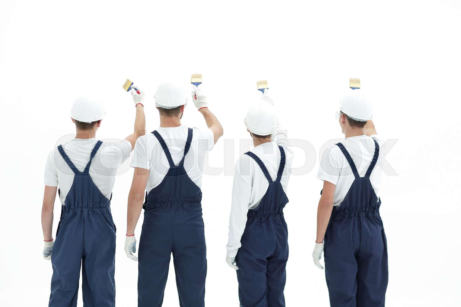 rear view.team of construction workers paint a wall. | Stock image ...