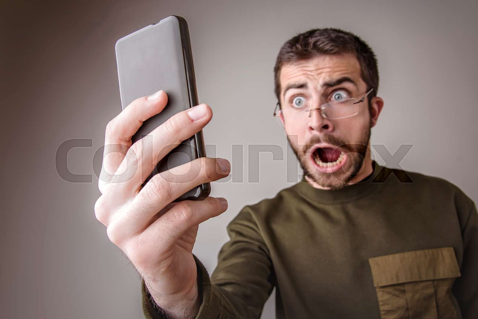 Furious man yelling at his phone | Stock image | Colourbox