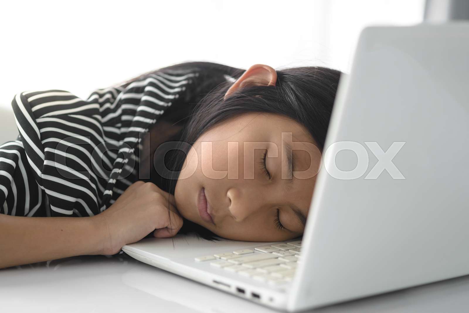 Sleeping girl with laptop at home. | Stock image | Colourbox