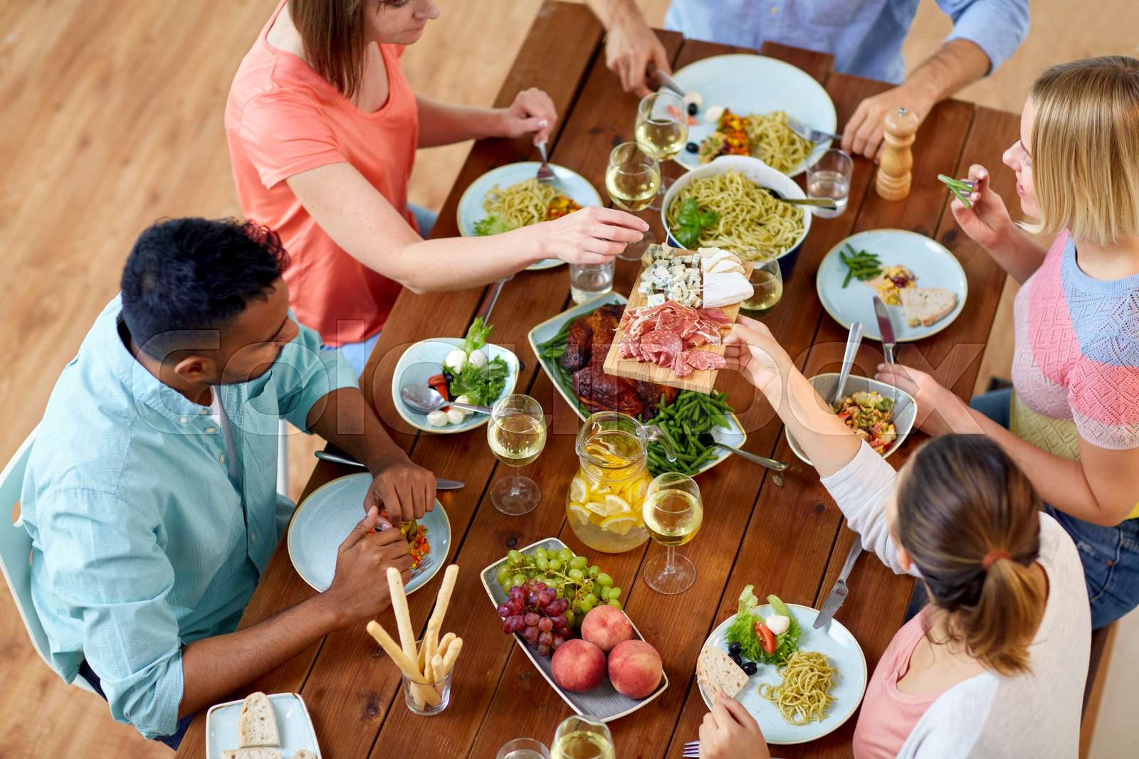 group of people eating at table with food | Stock image | Colourbox