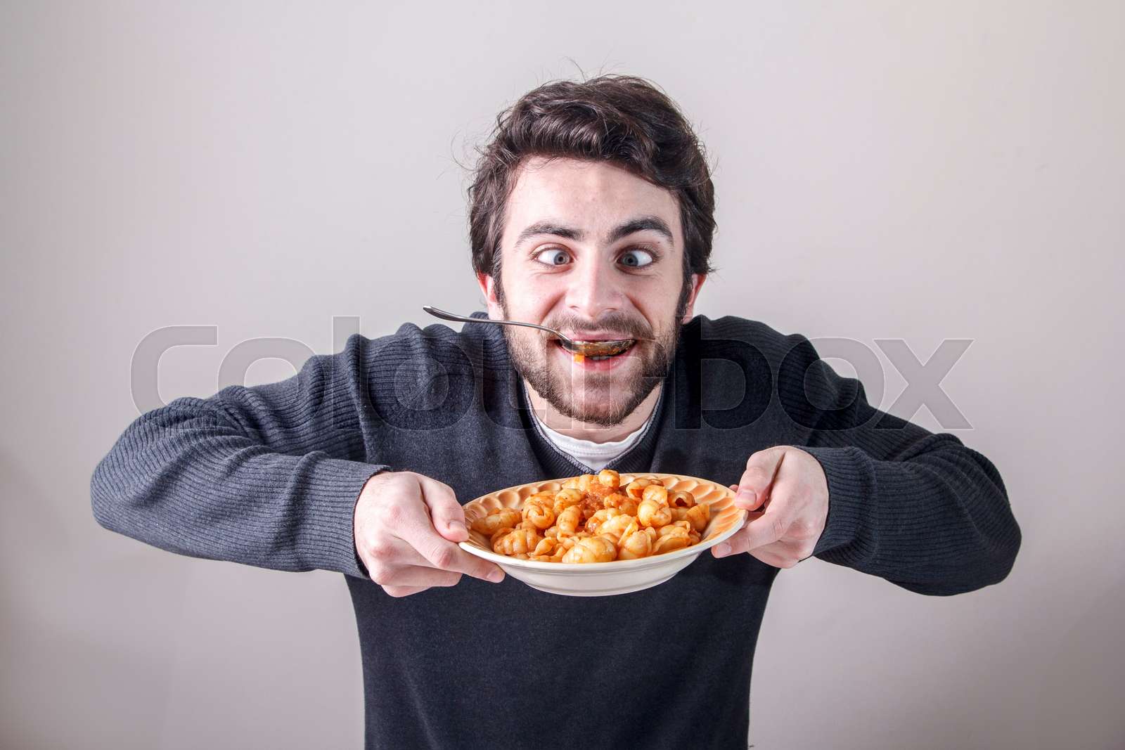 Hungry man eating food | Stock image | Colourbox