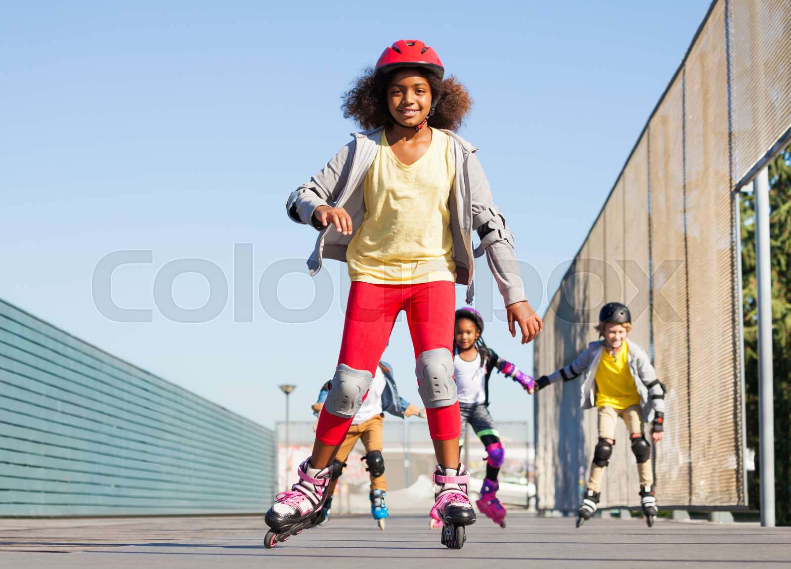African girl rollerblading with friends at stadium | Stock image ...