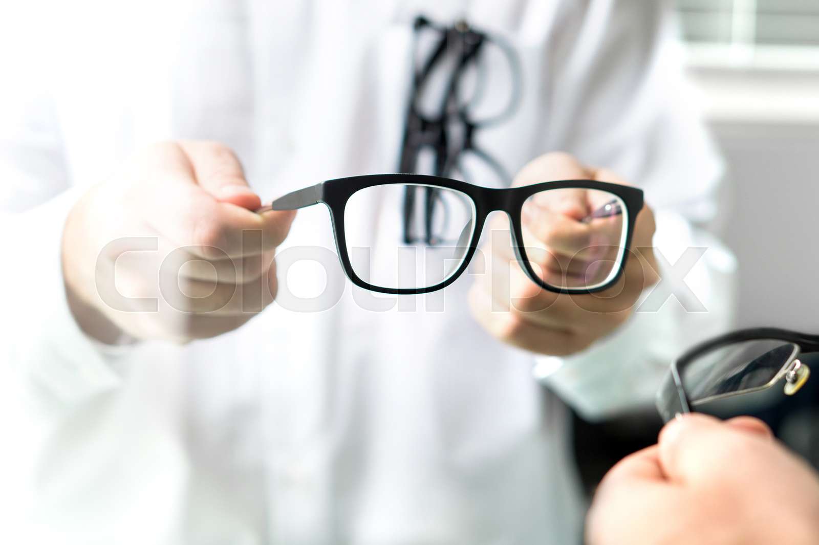 Optician Showing New Glasses To Customer For Trying Eye Doctor Giving Patient Lenses Stock