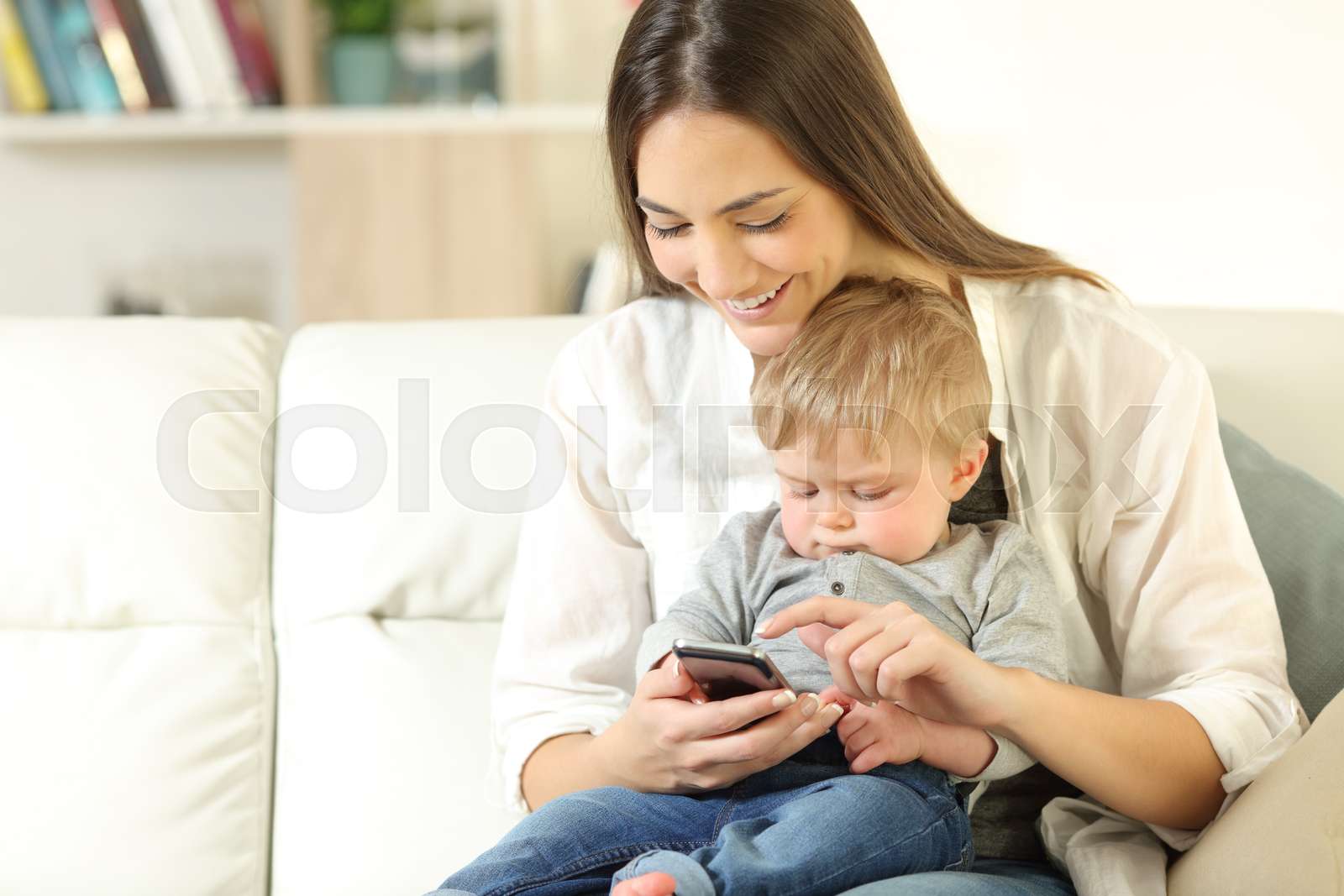 Mother showing smart phone content to his baby son | Stock image ...