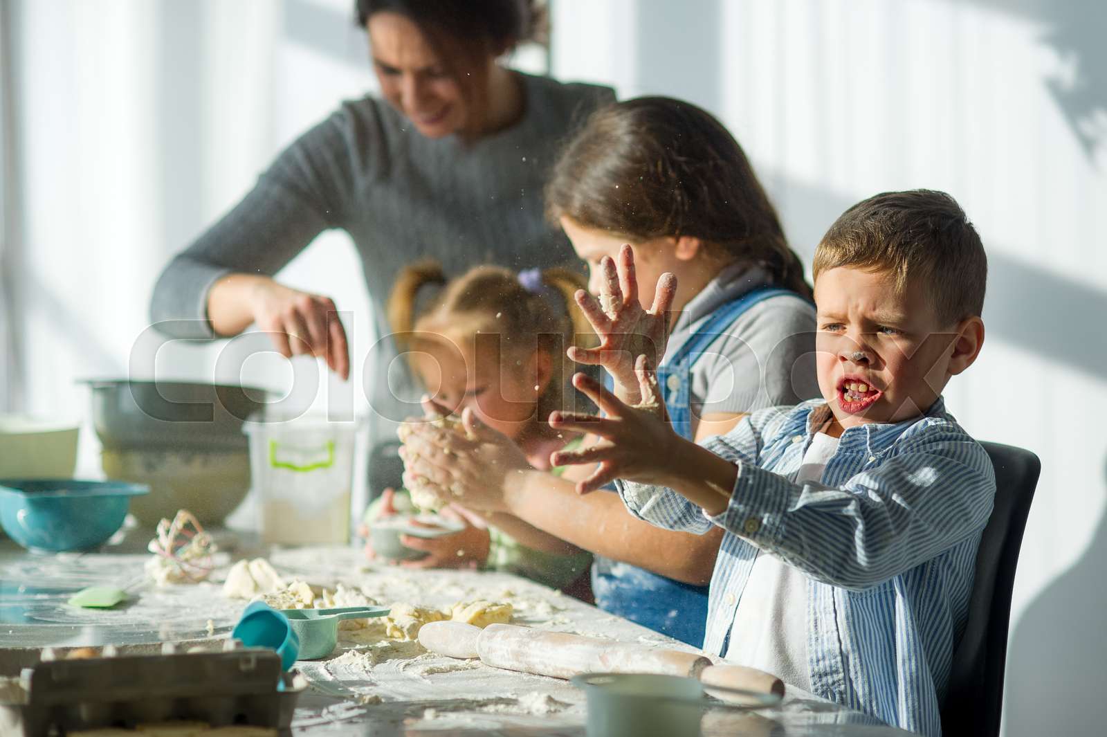 Mother and three children prepare something from the dough. | Stock ...