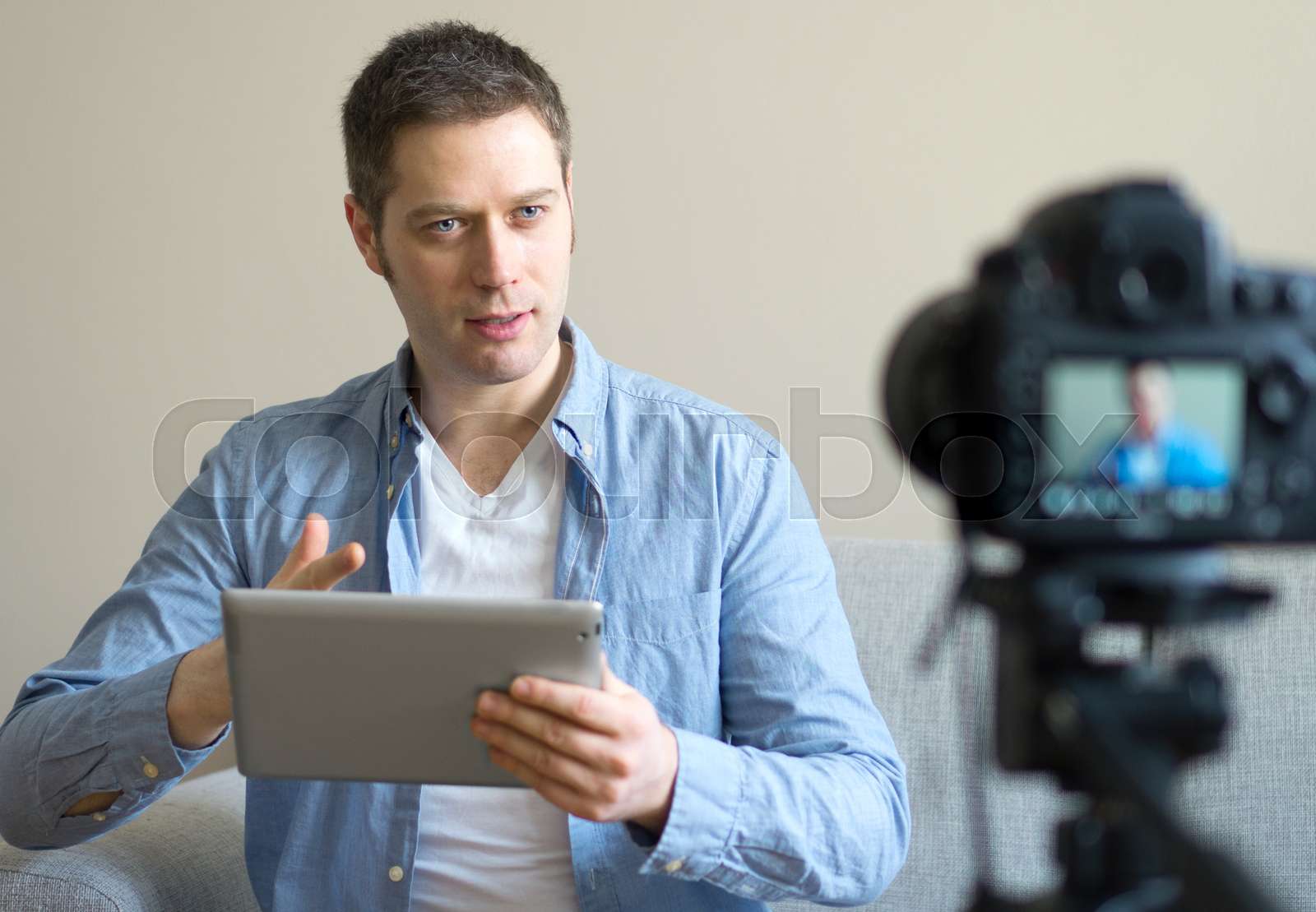Handsome man making video blog about tablet pc. | Stock image | Colourbox
