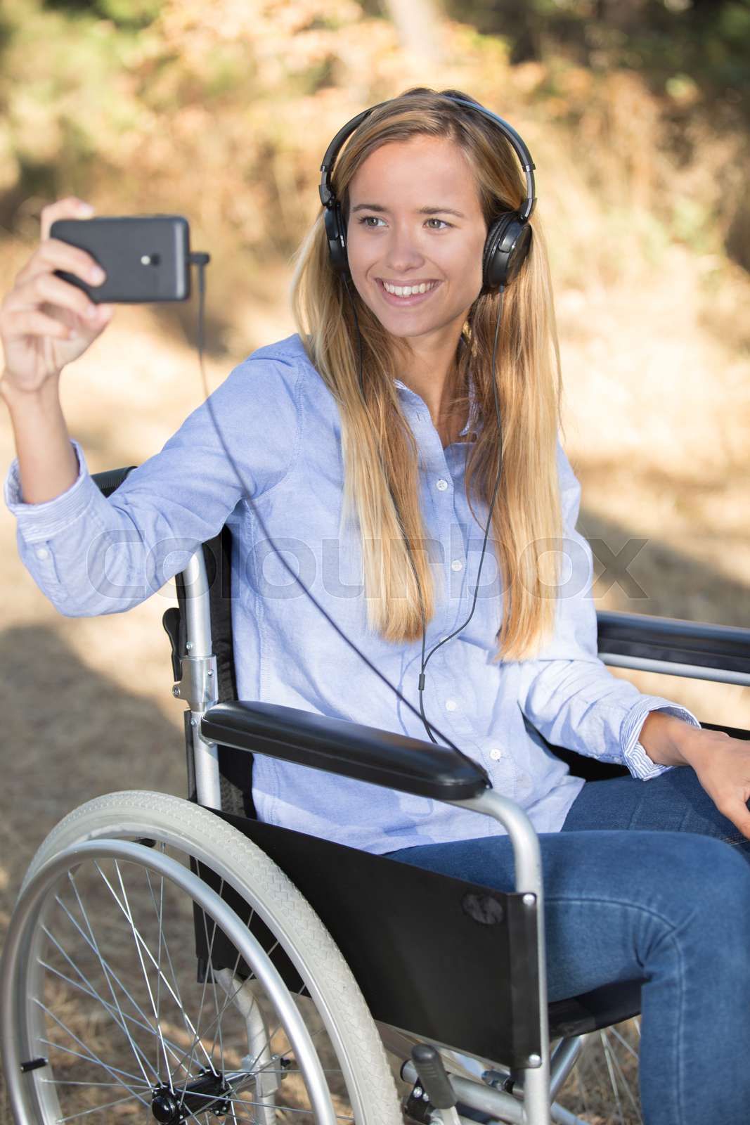 disabled woman in the wheelchair taking a selfie | Stock image | Colourbox
