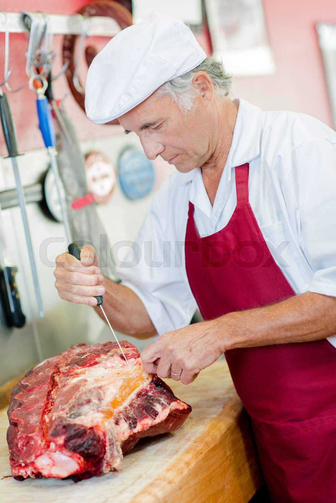 Skilled butcher preparing cuts of beef | Stock image | Colourbox