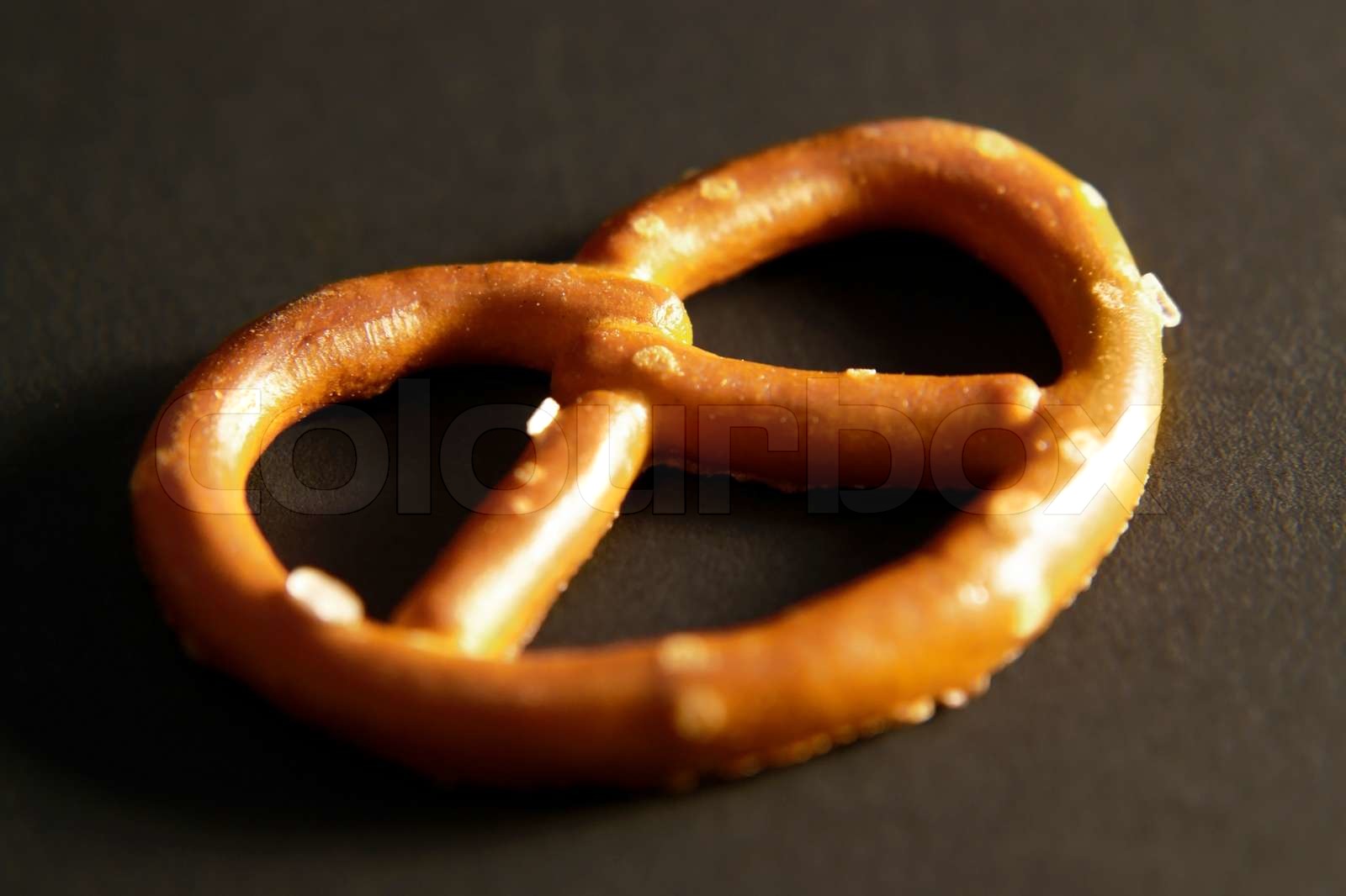 closeup of a salted small pretzel in dark back A pretzel is a special ...