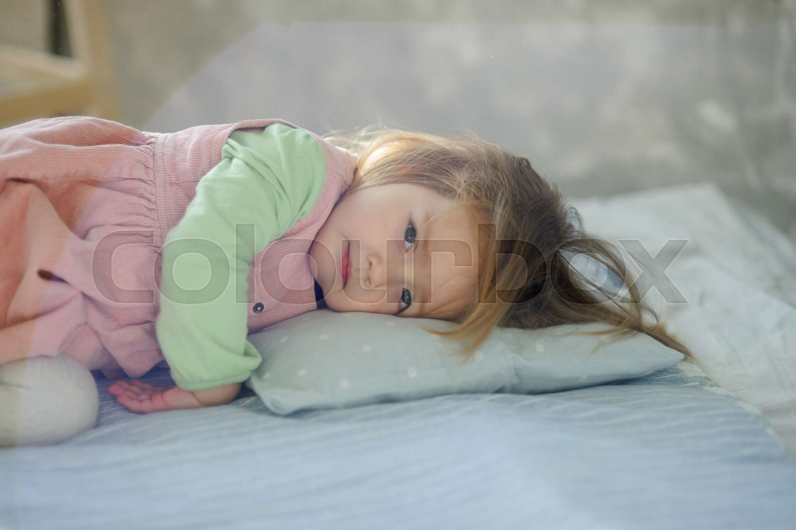 Little girl falls asleep on the bed. | Stock image | Colourbox