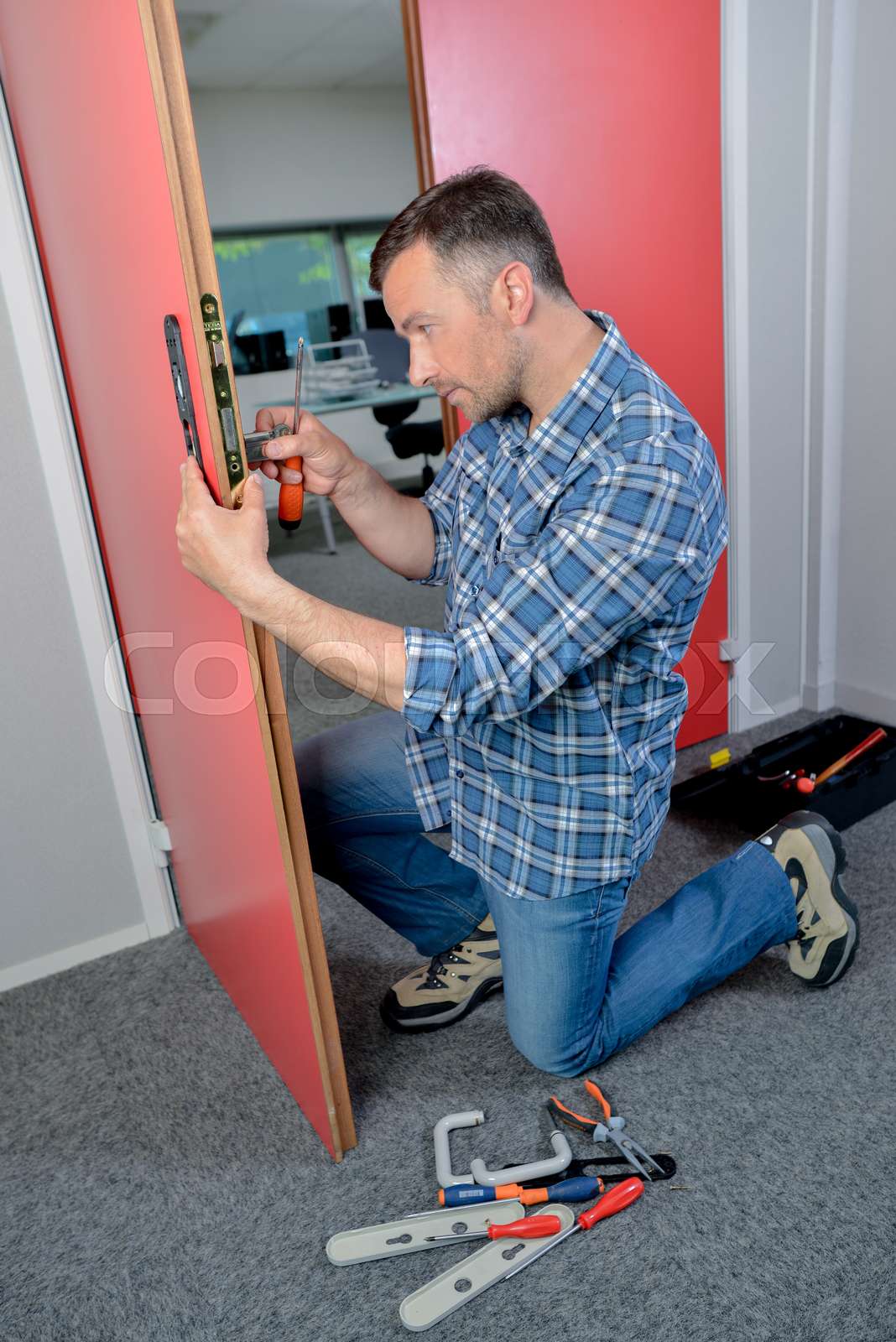 man fixing a door | Stock image | Colourbox
