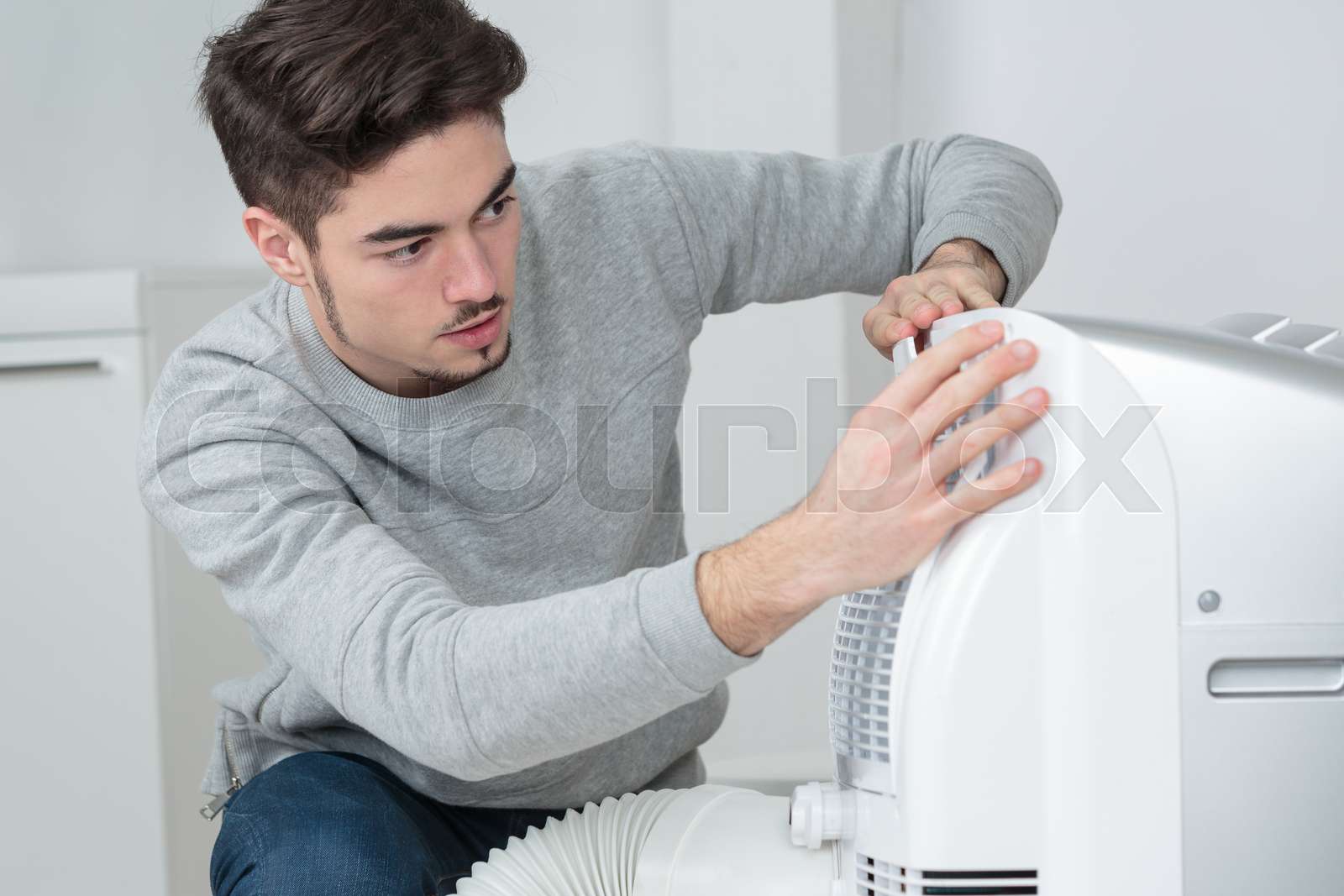 Man working on air conditioning unit | Stock image | Colourbox