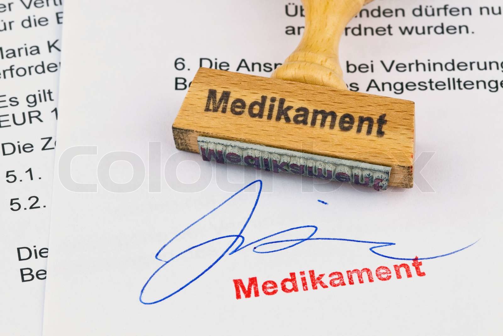 et stempel fremstillet af træ liggende på et dokument | Stock foto ...