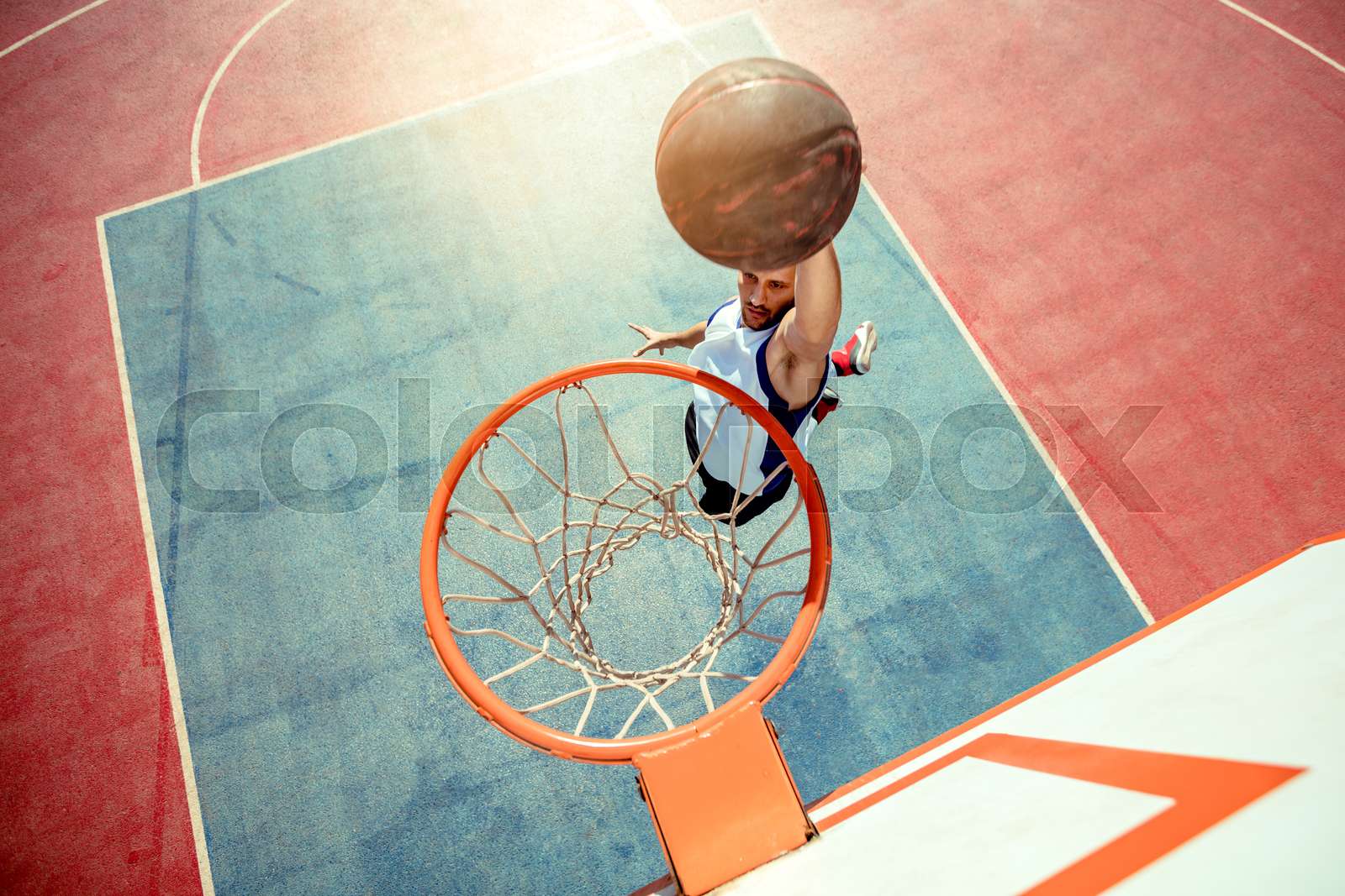 High angle view of basketball player dunking basketball in hoop | Stock ...