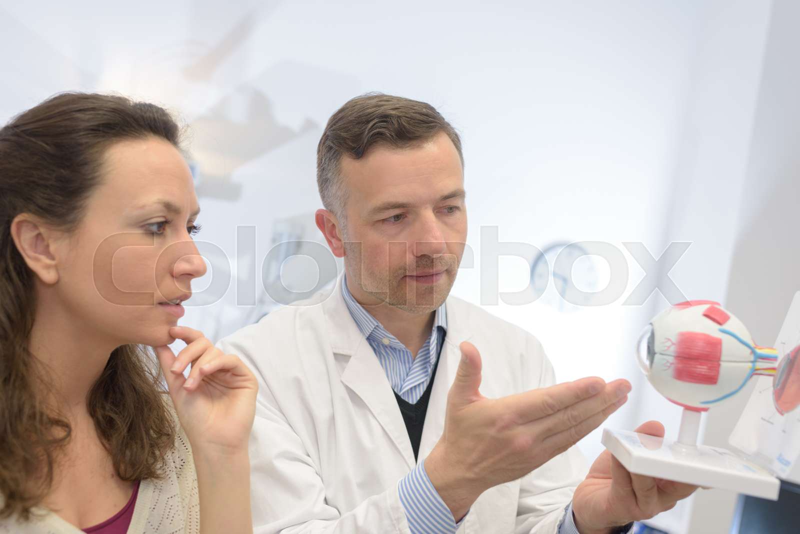 ophthalmologist explaining patient with a model of the eye | Stock ...