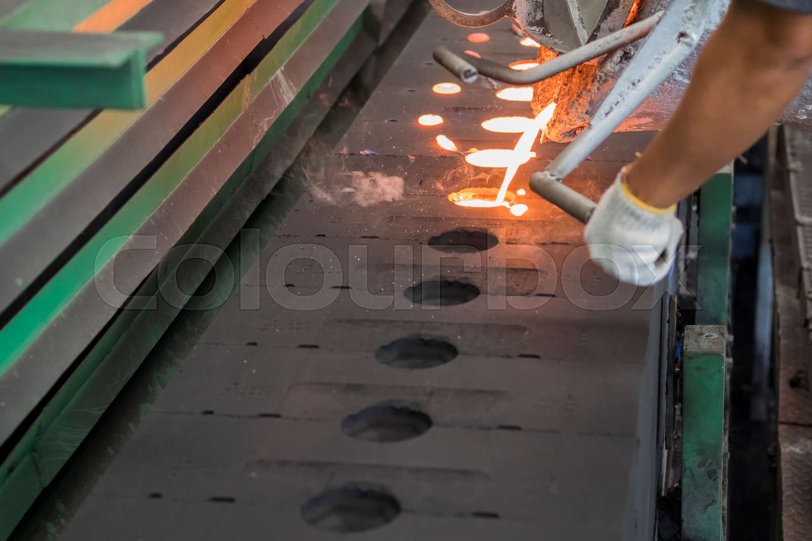 molten metal pouring in mold | Stock image | Colourbox
