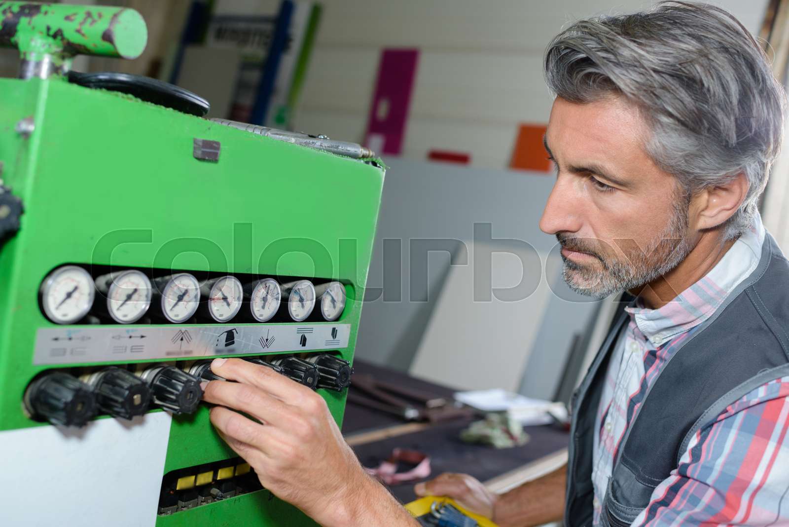 Man adjusting dial on control panel | Stock image | Colourbox