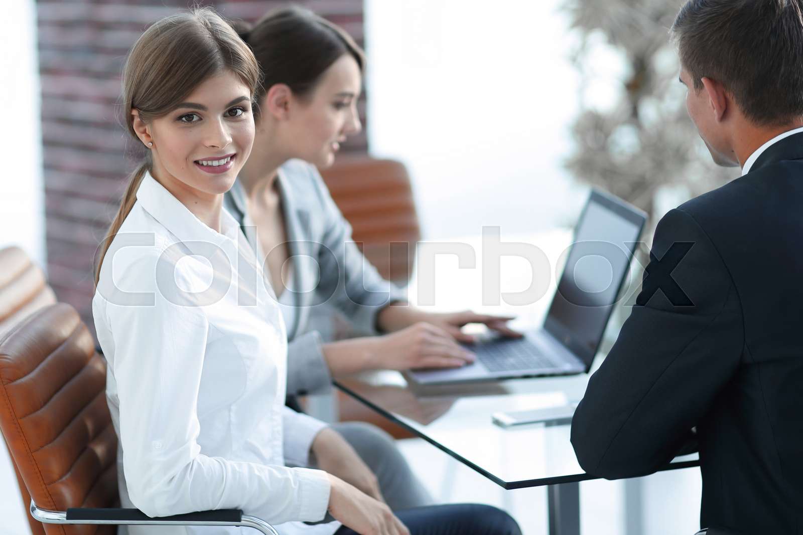office workers sitting behind a Desk. | Stock image | Colourbox