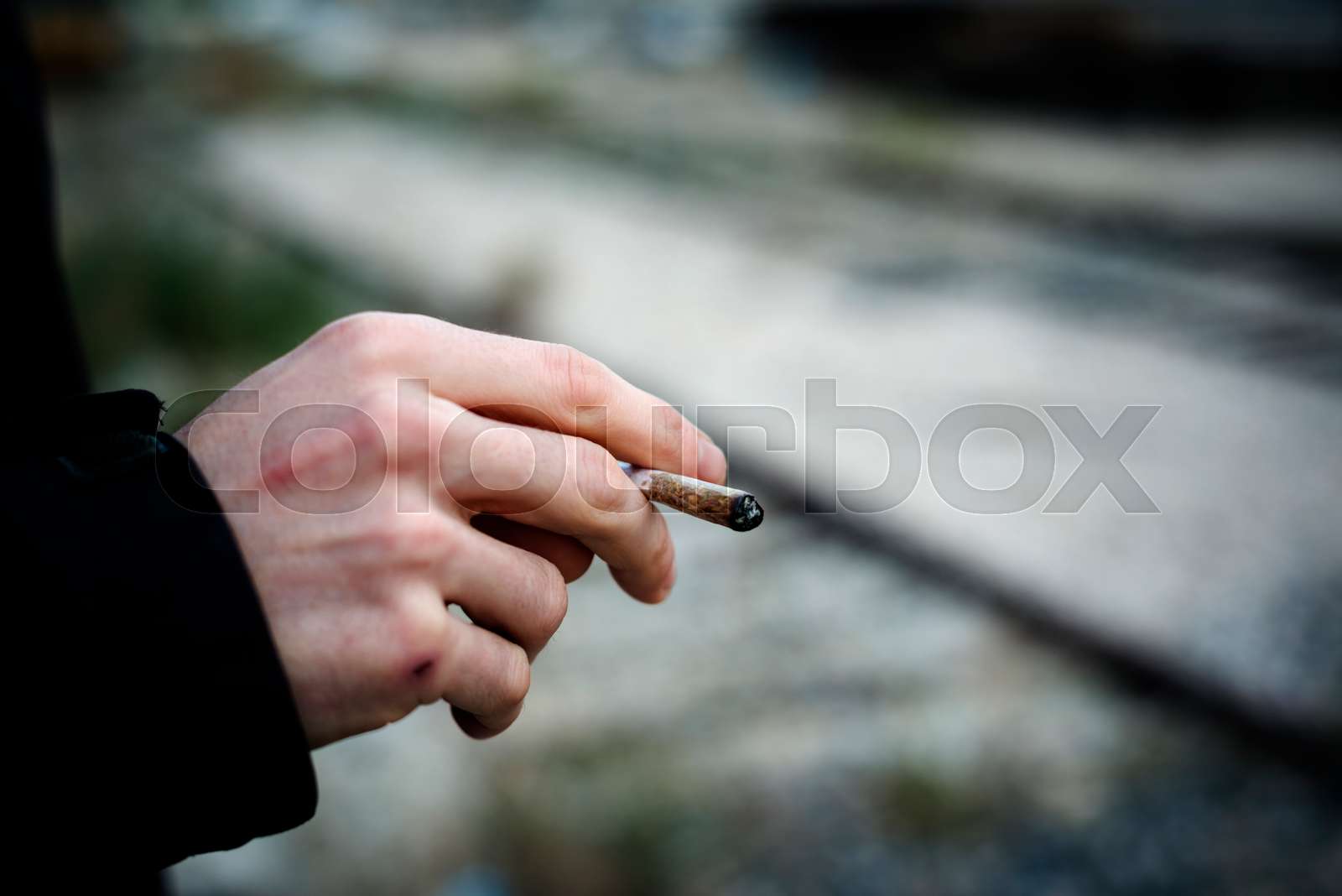 man smoking a hand-rolled cigarette or a joint | Stock image | Colourbox