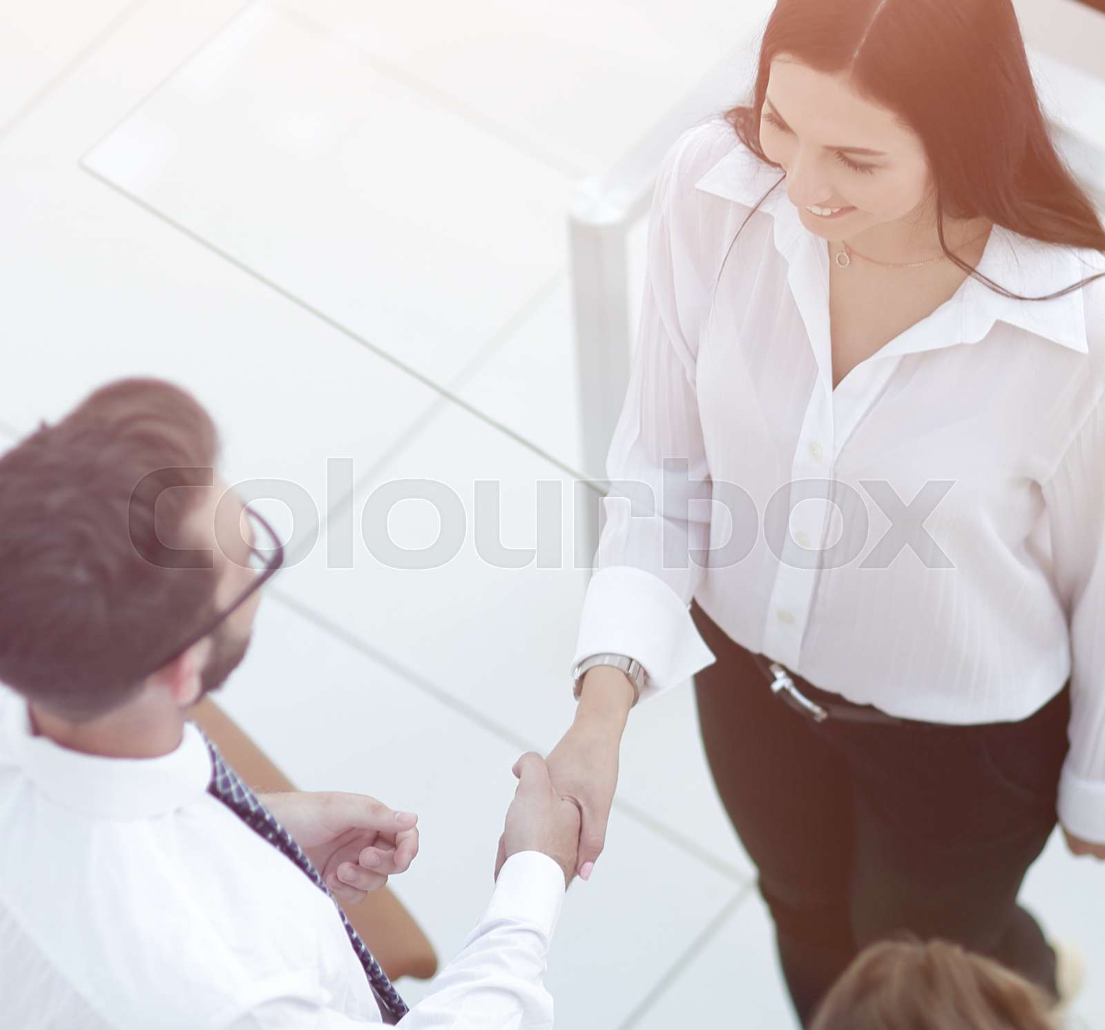 handshake manager and employee near the workplace | Stock image | Colourbox