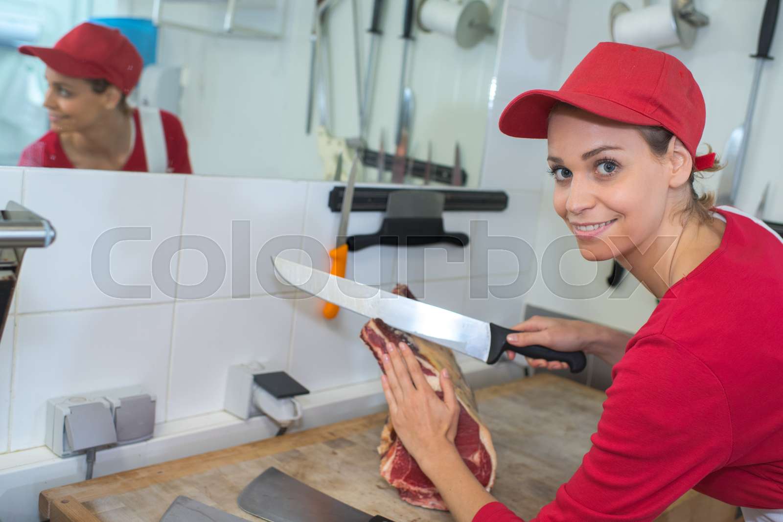 female butcher cutting meat | Stock image | Colourbox