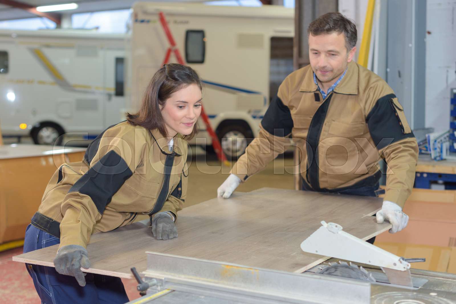 Workers pushing panel through saw bench | Stock image | Colourbox