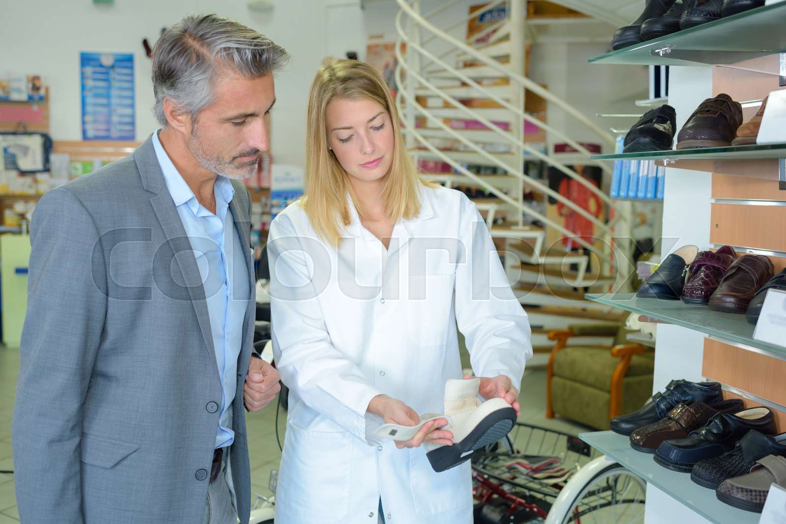 Woman showing shoes to customer | Stock image | Colourbox