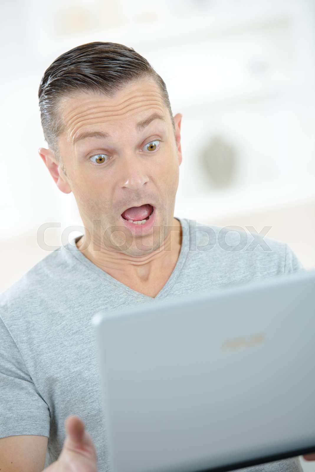 surprised man looking into computer screen | Stock image | Colourbox
