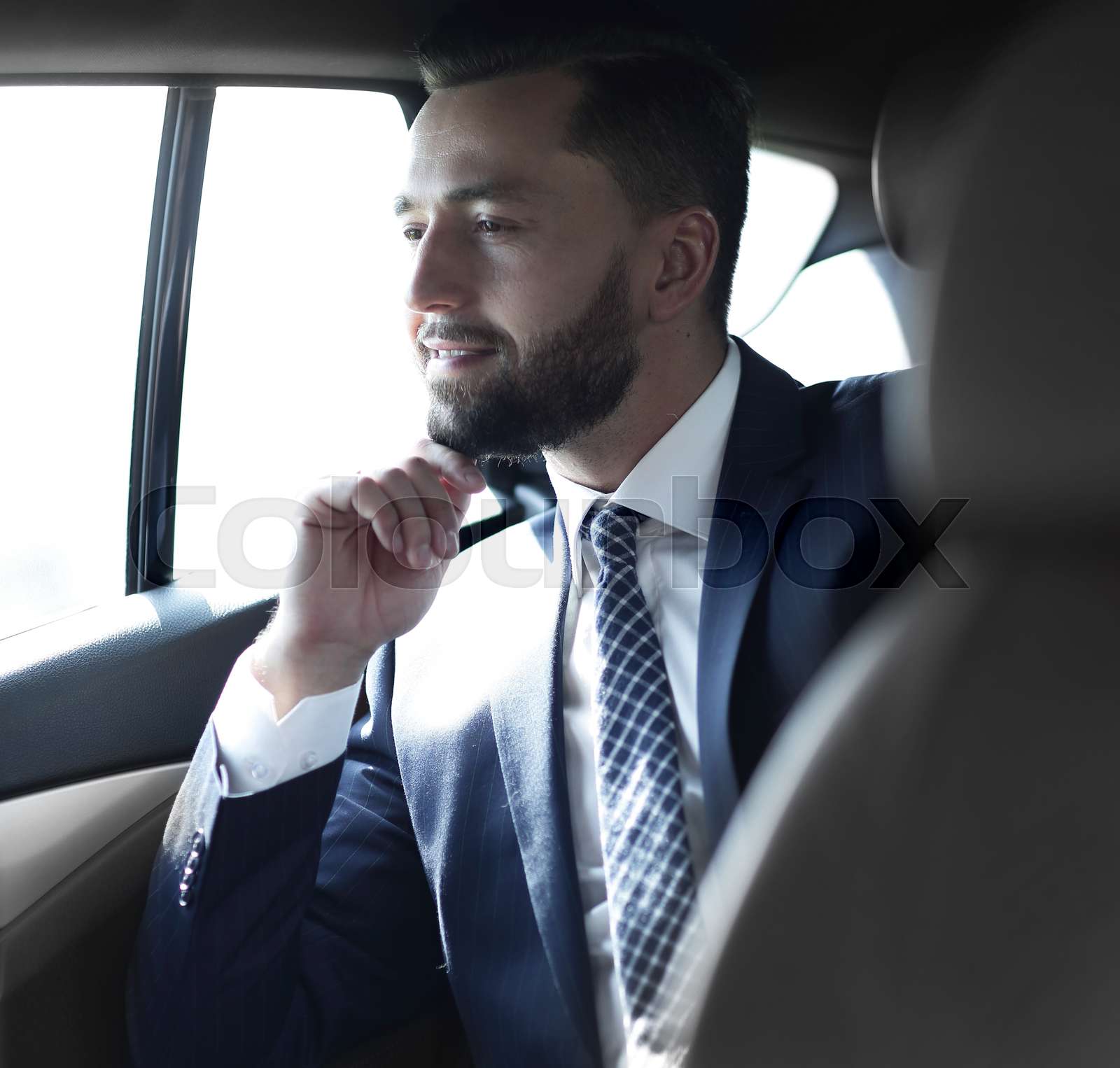 Smiling business man sitting in the back seat of a car | Stock image ...