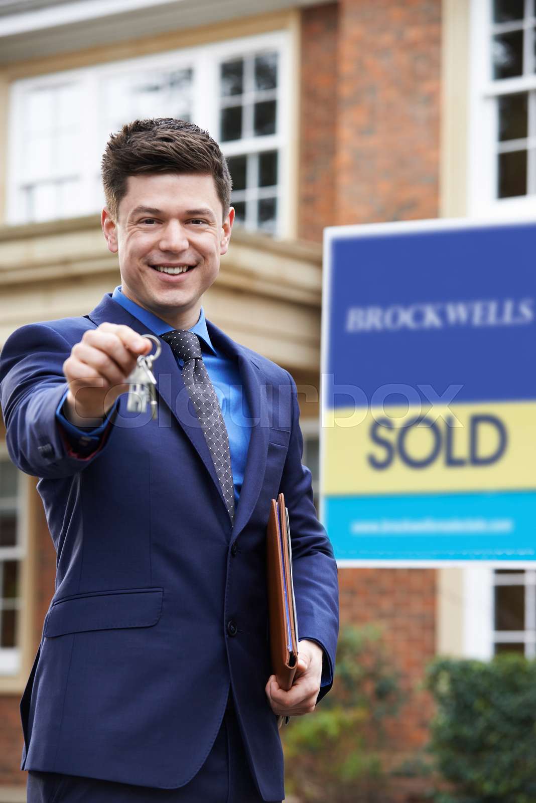 Male Realtor Standing Outside Residential Property Holding Keys | Stock ...