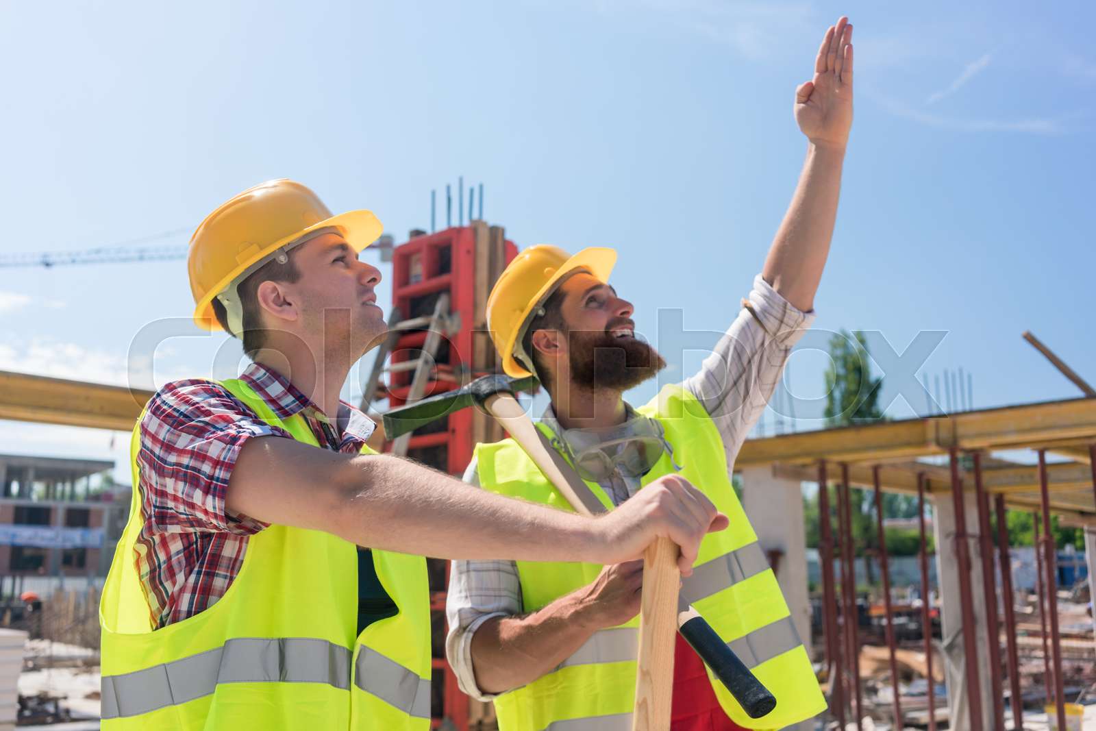 Determined young worker pointing up while imagining the height of a ...